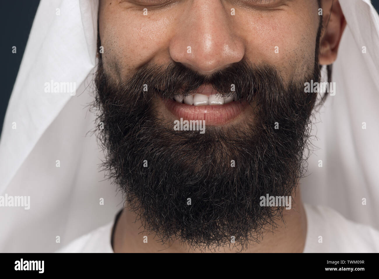 Close up portrait of arabian saudi businessman on dark blue studio ...