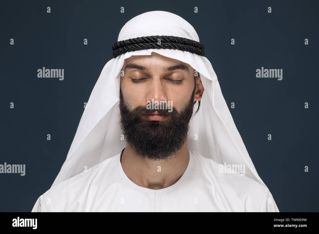 Half-length portrait of arabian saudi businessman on dark blue studio ...