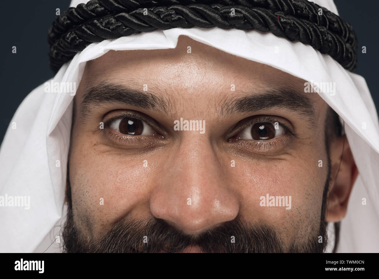 Close up portrait of arabian saudi businessman on dark blue studio ...