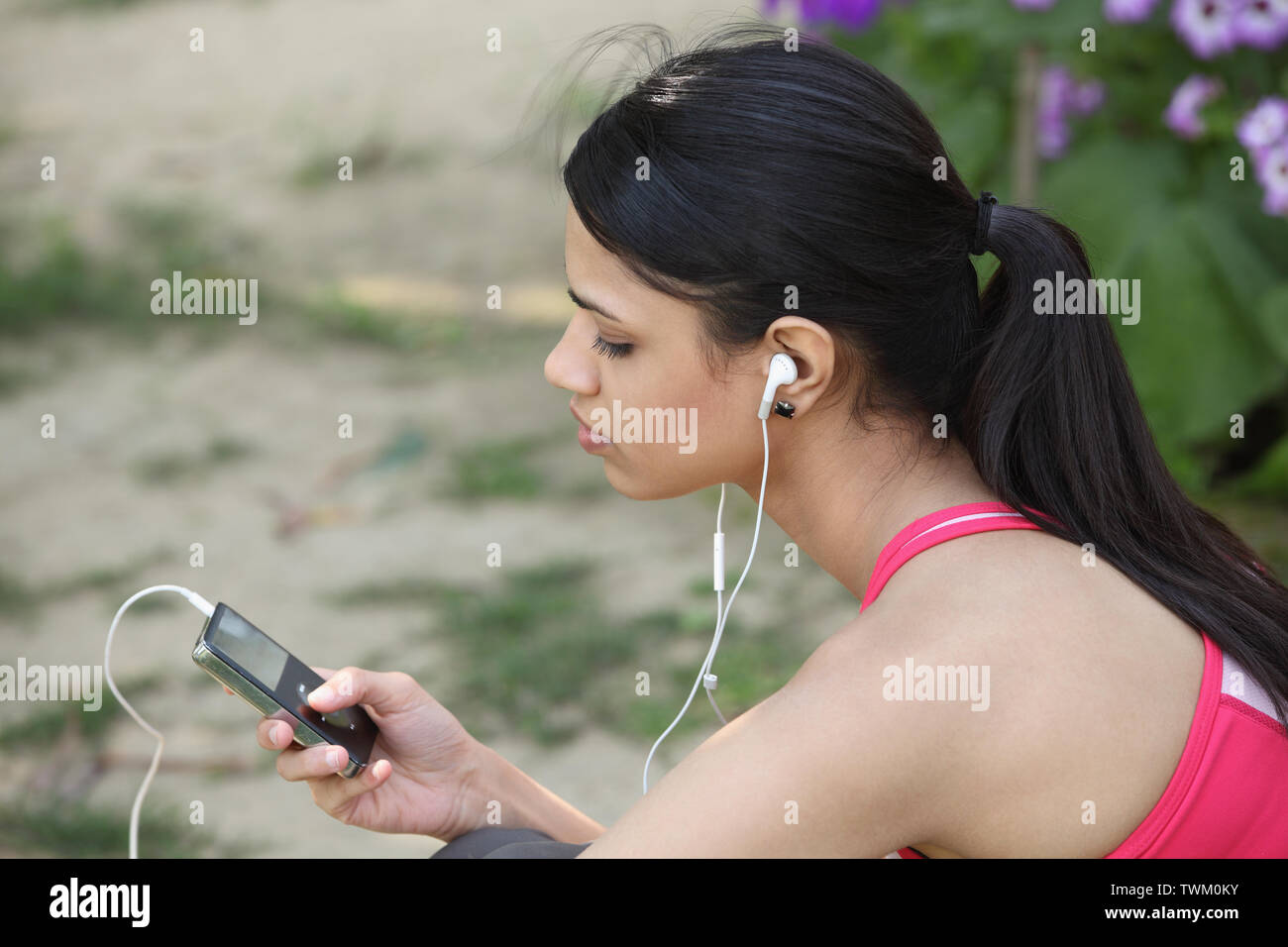 Woman listening to music on an mp3 player Stock Photo - Alamy