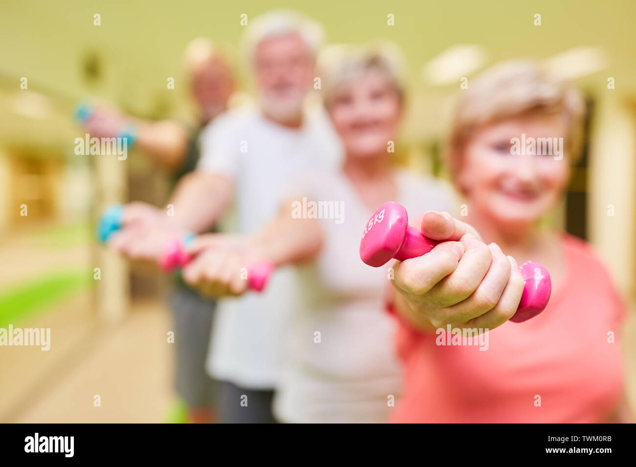 Seniors exercise with dumbbells for fitness and muscle building in ...