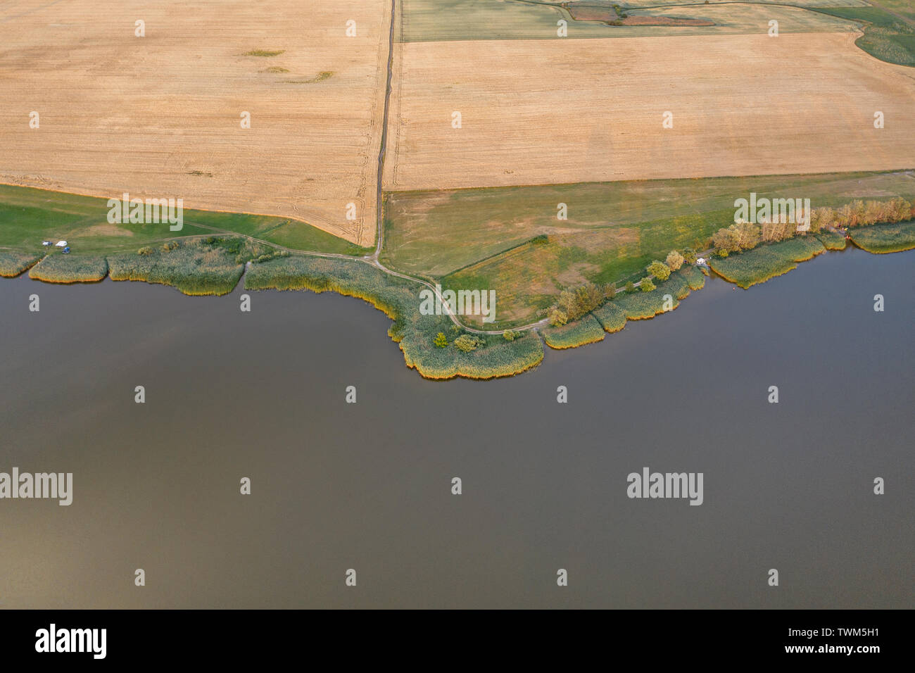 Top down view of a lake shore with the road and field Stock Photo - Alamy