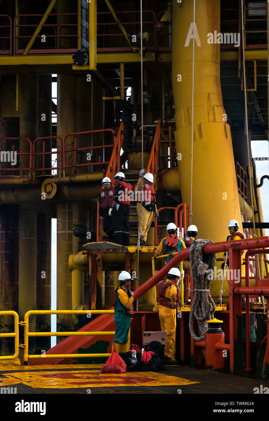 oil platform crew climbing oil platform using swing rope to transfer ...