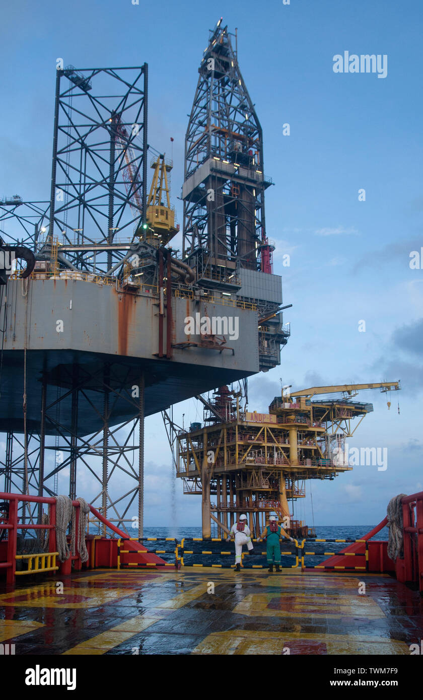 jack up rig with oil platform during morning with two marine crew ...
