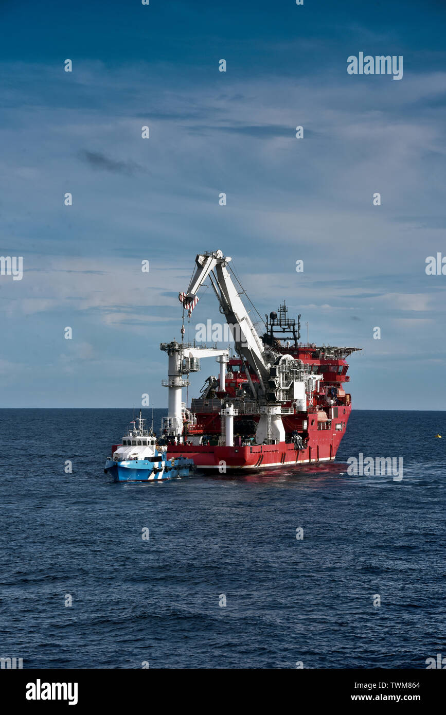 offshore vessel transfering cargo to fast crew boat to send it back to ...