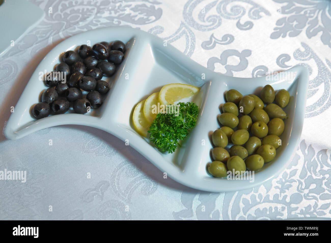 Black and green olive plate inside. Lemon, greens, olives. Green olives ...