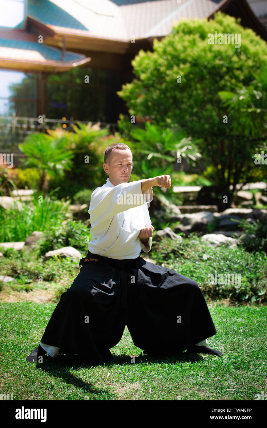 Young serious man aikido master in traditional costume Stock Photo - Alamy