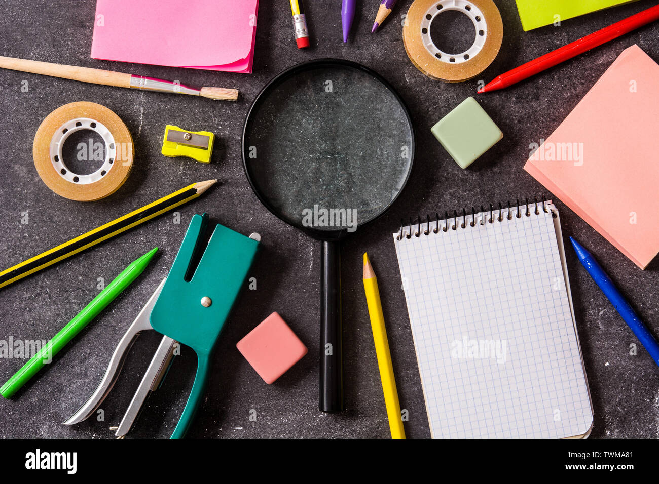 Assorted of school supplies on black slate. Back to school concept ...