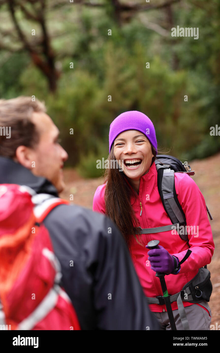 Couple having fun laughing hiking in forest. Multicultural woman and ...