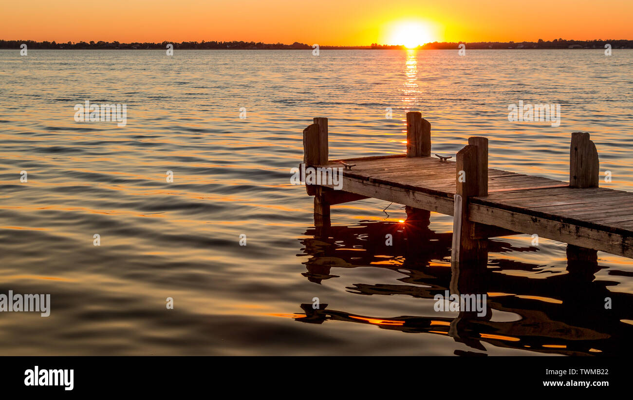 Empty boat dock on lake at sunset in Mount Dora Stock Photo - Alamy