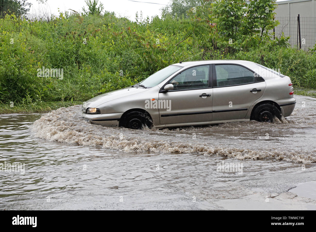 Car Driving Through Flooded Road Natural Disaster Stock Photo - Alamy
