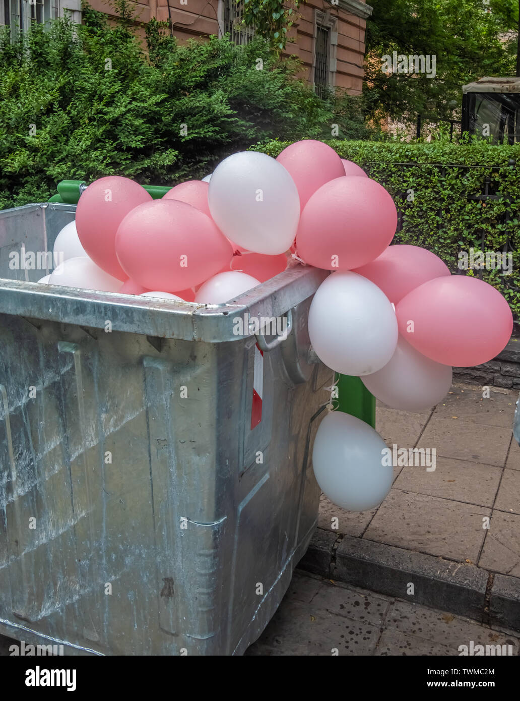 Party's over. Balloons in a garbage container in the street Stock Photo ...