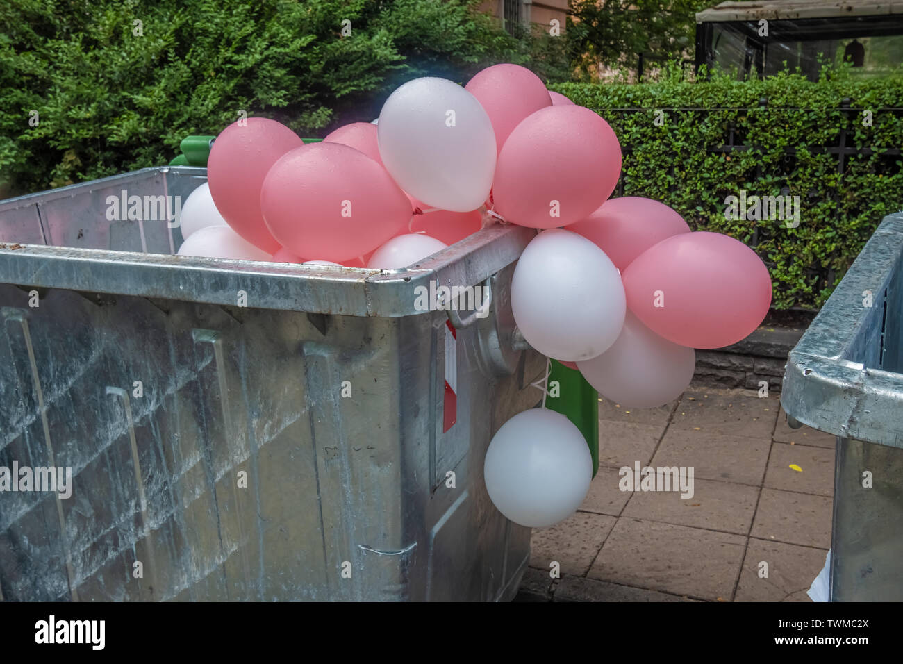 Party's over. Balloons in a garbage container in the street Stock Photo ...
