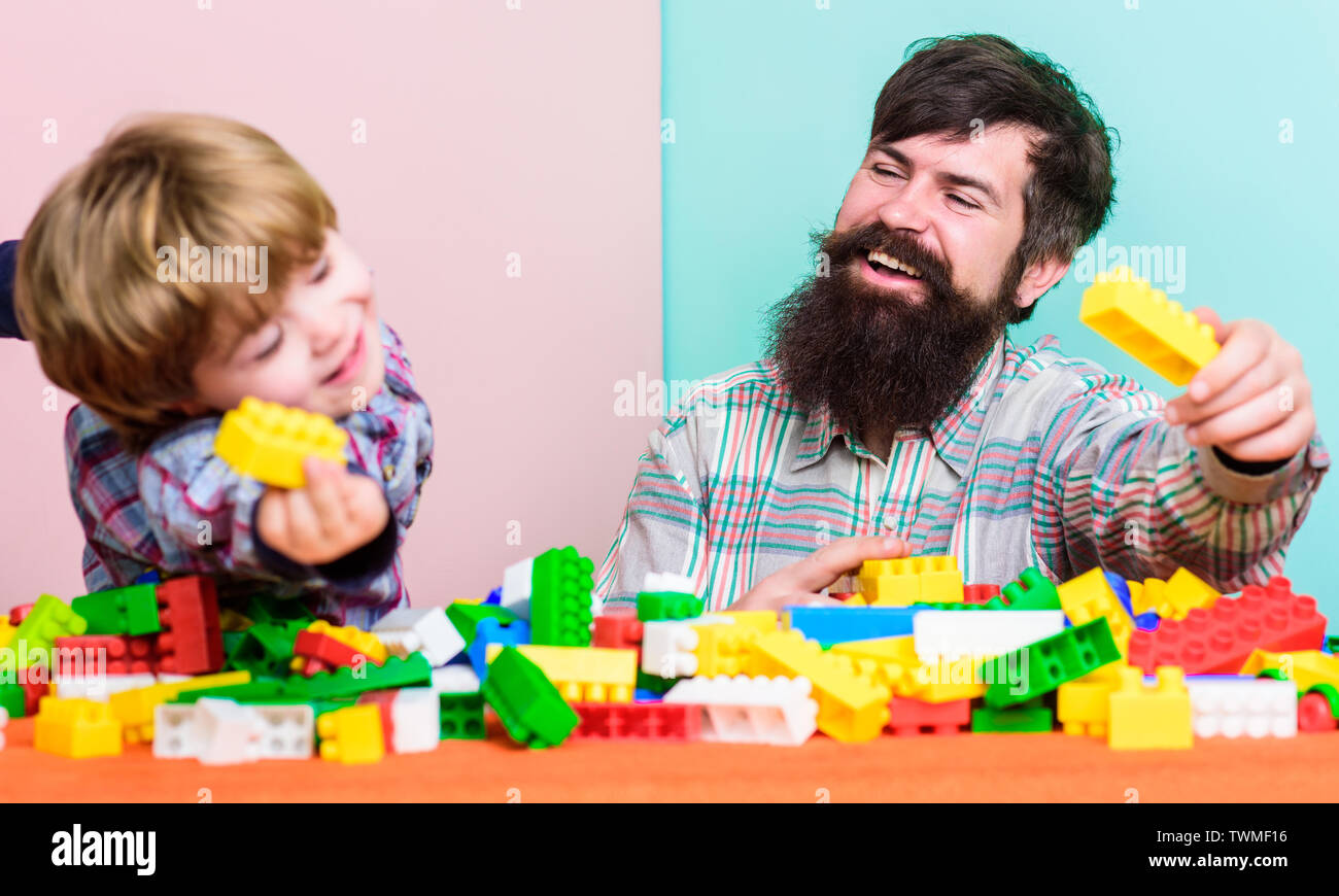Dad and kid build plastic blocks. Child care development. Family ...