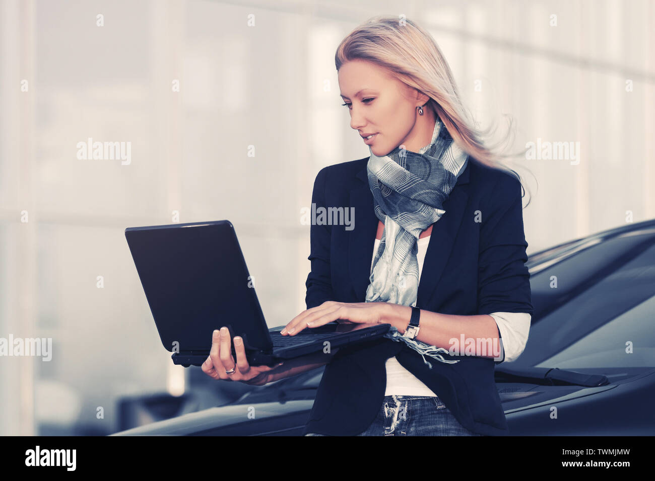 Young fashion business woman with laptop outside her car Stylish female ...