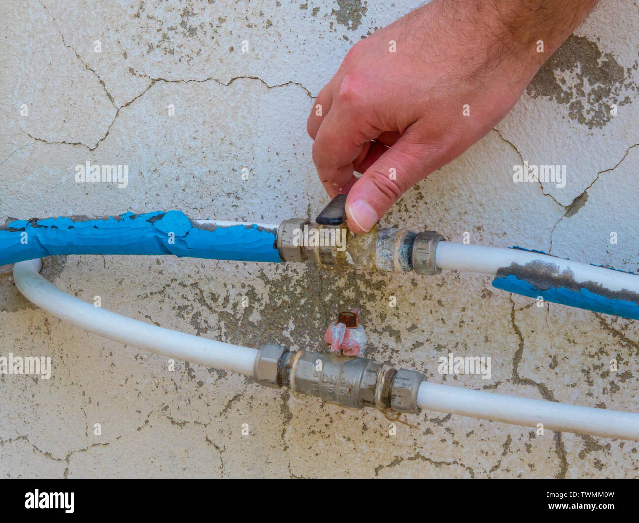 Hand using an old rusty faucet on a pipe outside Stock Photo - Alamy