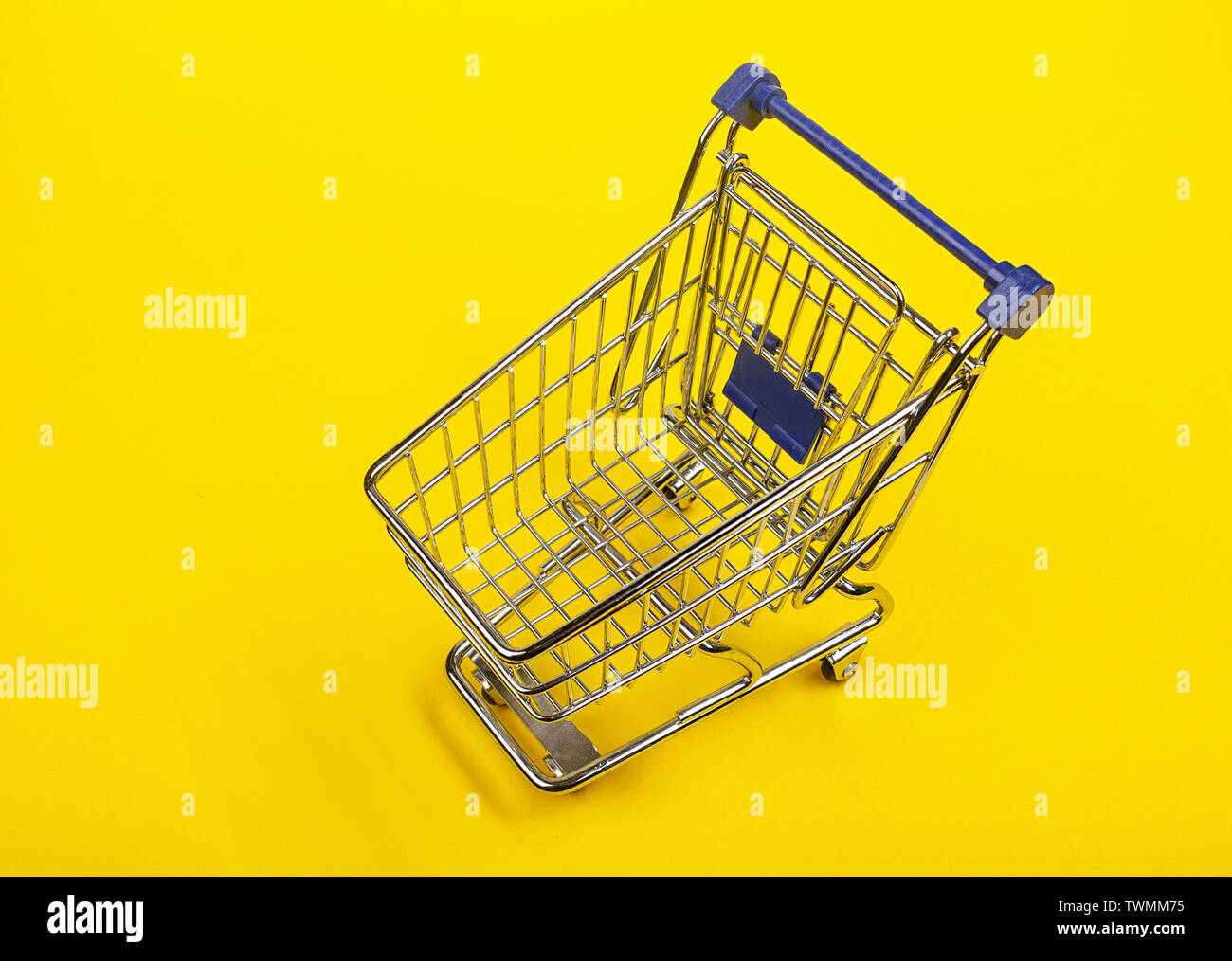 Mini shopping cart on yellow background, consumer concept, minimalism ...
