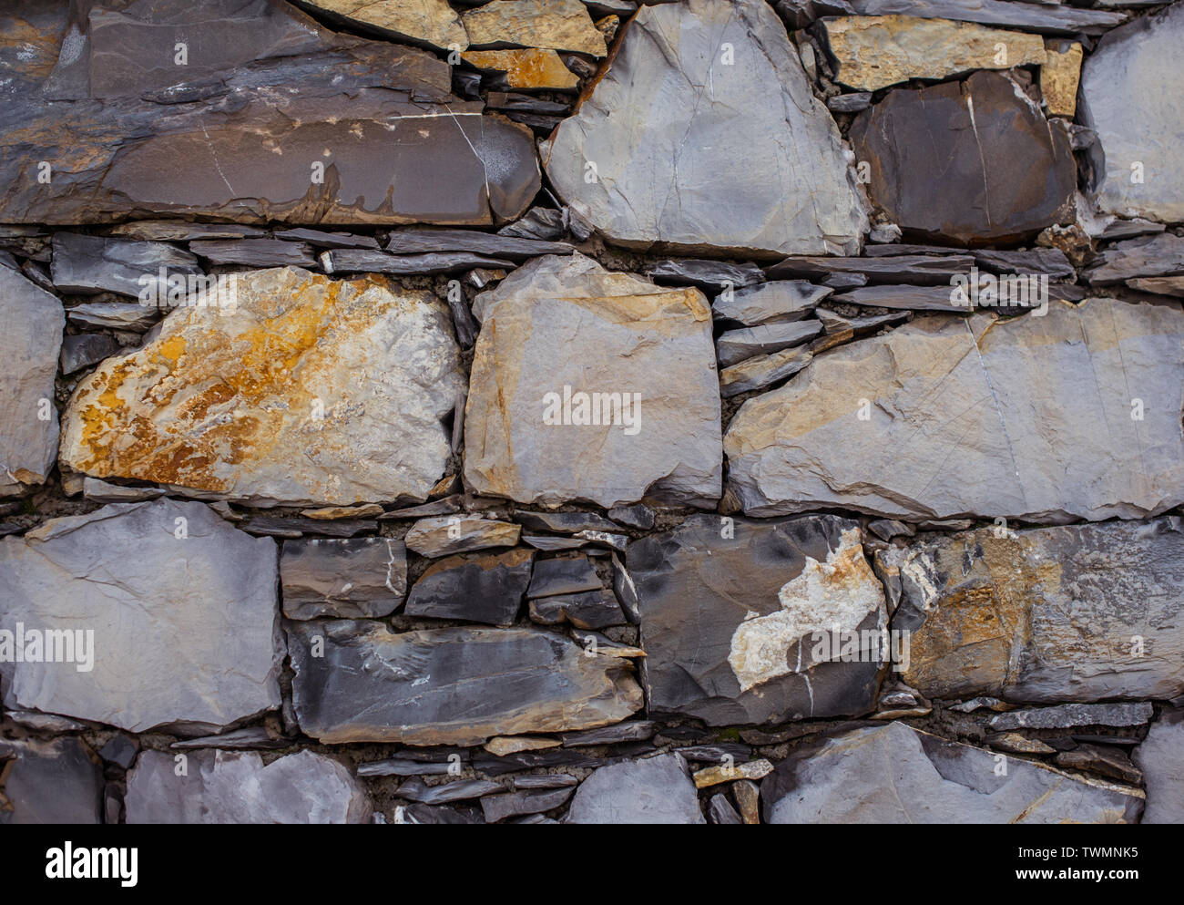 Masonry walls of different layered stones Stock Photo - Alamy