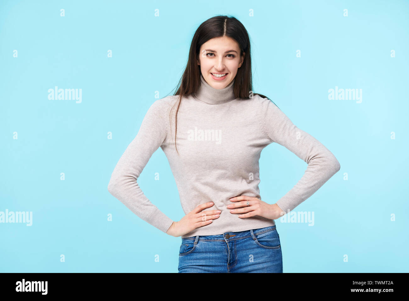 studio portrait of a beautful caucasian woman, arms akimbo, looking at ...