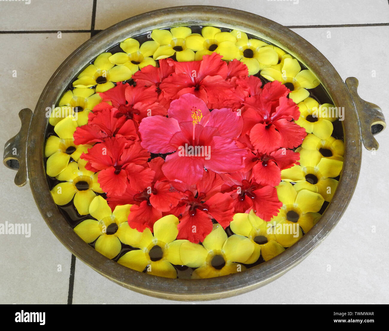 Indian bronze bowl with red and yellow flowers in Kerala Stock Photo ...