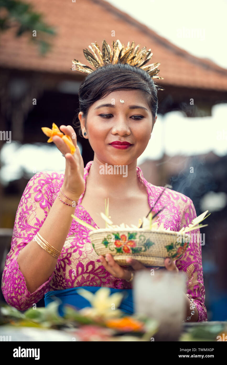 Portrait of Balinese woman praying with offering for gods Stock Photo ...
