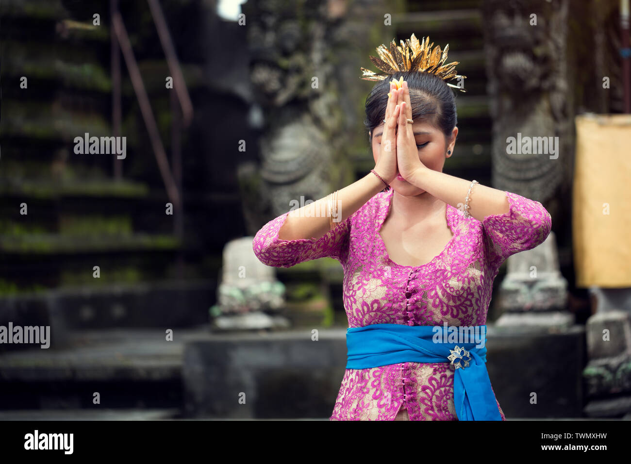 young woman is praying in Balinese temple during ceremony Stock Photo ...