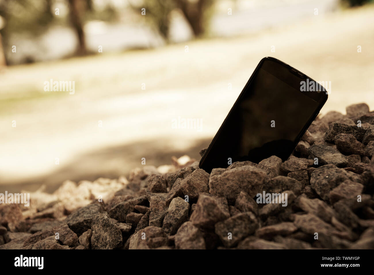 Broken cellphone abandoned and lost among the gravel Stock Photo - Alamy
