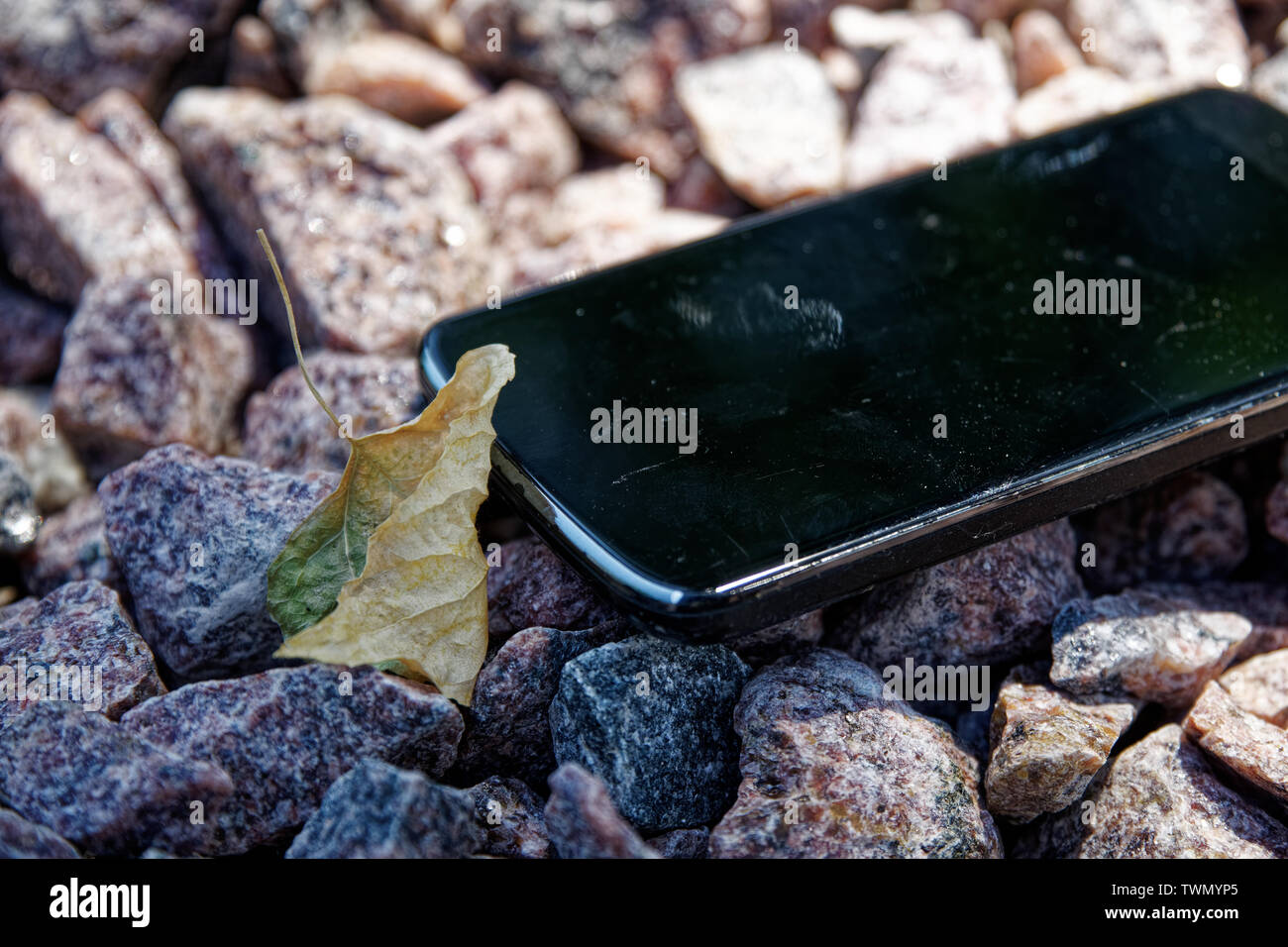 Broken cellphone abandoned and lost among the gravel Stock Photo - Alamy