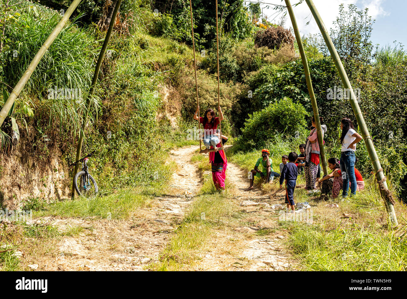 Dhulikhel, Nepal - Oct 18, 2018: A Nepalese girl plays swing made of ...