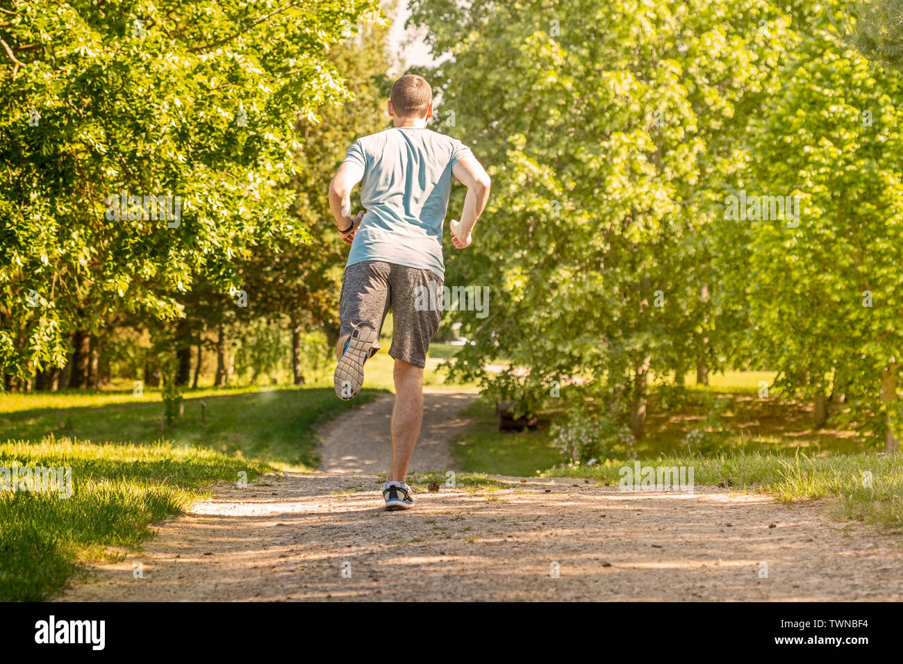 Back view of runner man running on a rural road Stock Photo - Alamy