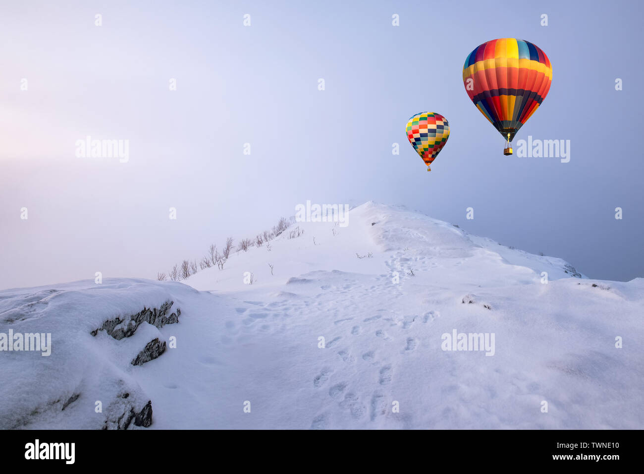Colorful hot air balloons flying on snow hill in blizzard Stock Photo ...