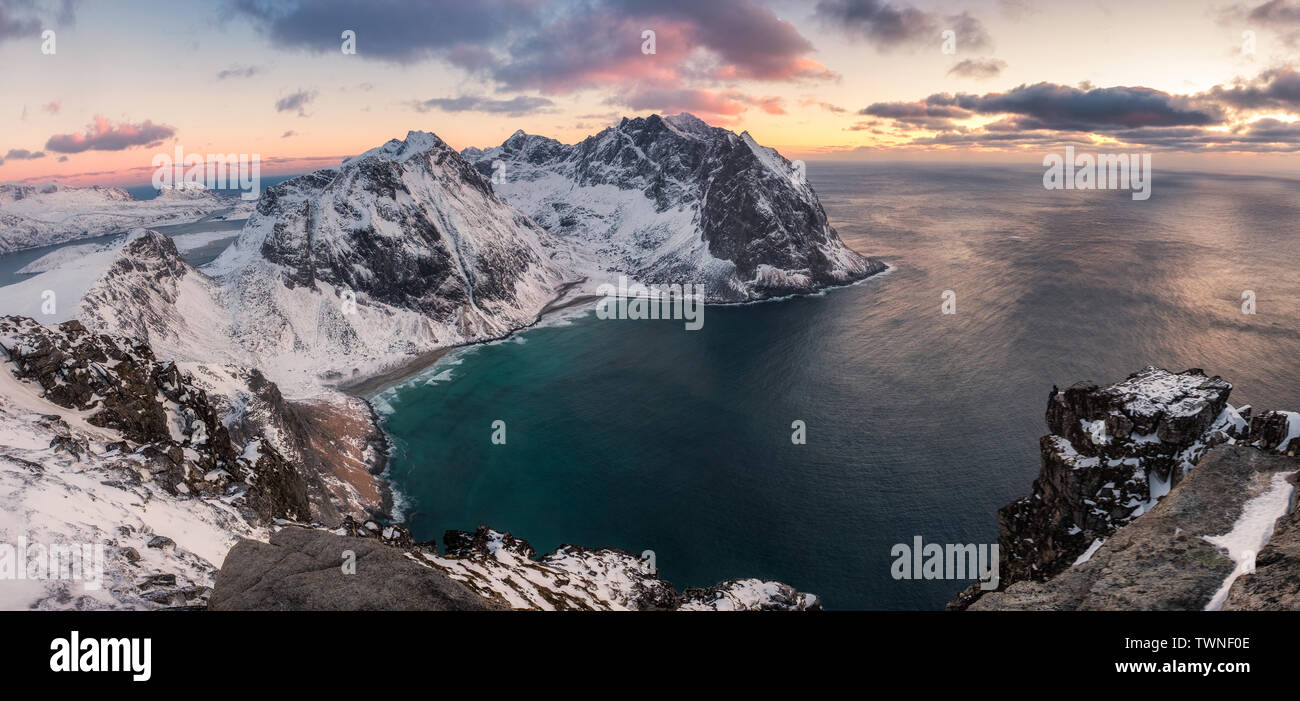 Panorama of Snowy mountain range with coastline at sunset. Ryten Mount ...