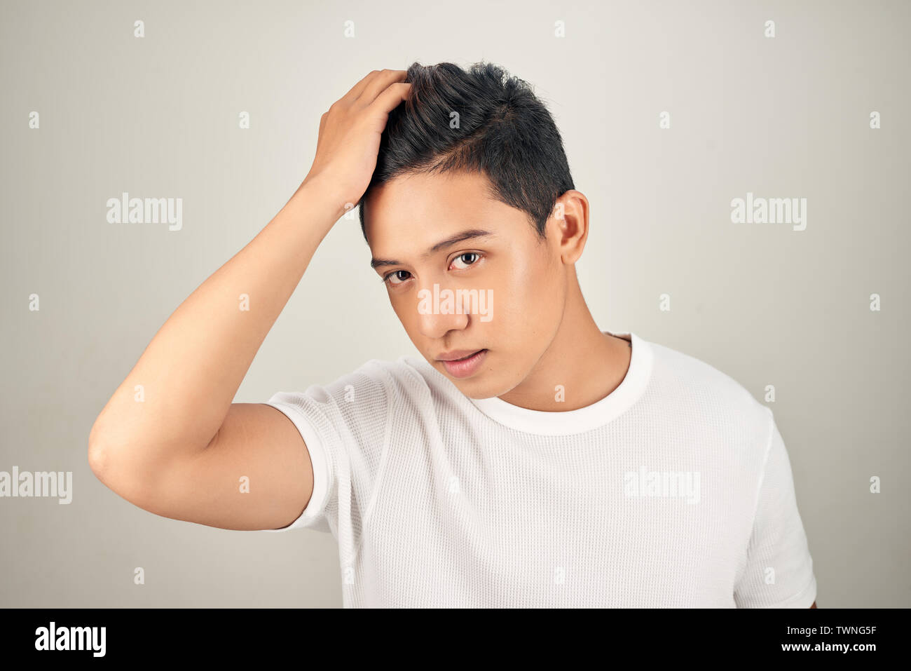 Fashion portrait of a handsome man. Man runs a hand through his hair ...