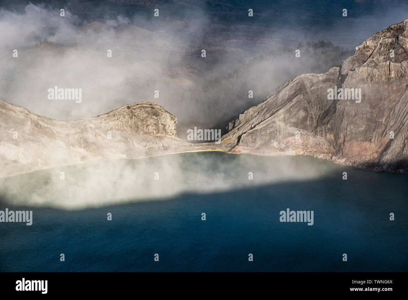 Turquoise lake in active crater volcano with smoke in morning Stock ...