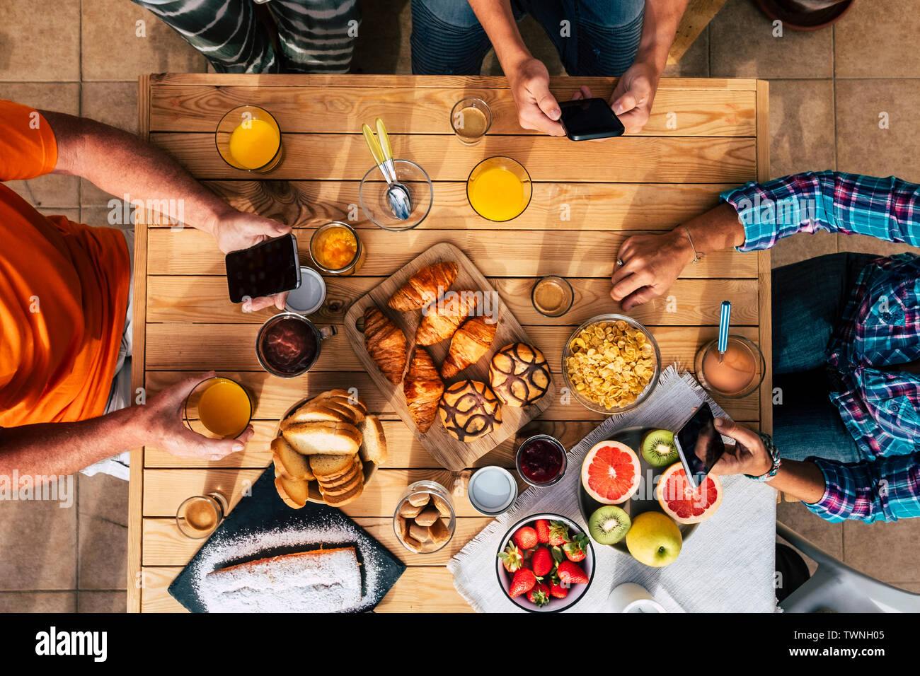 Breakfast time in vertical top view with family of friends eating ...