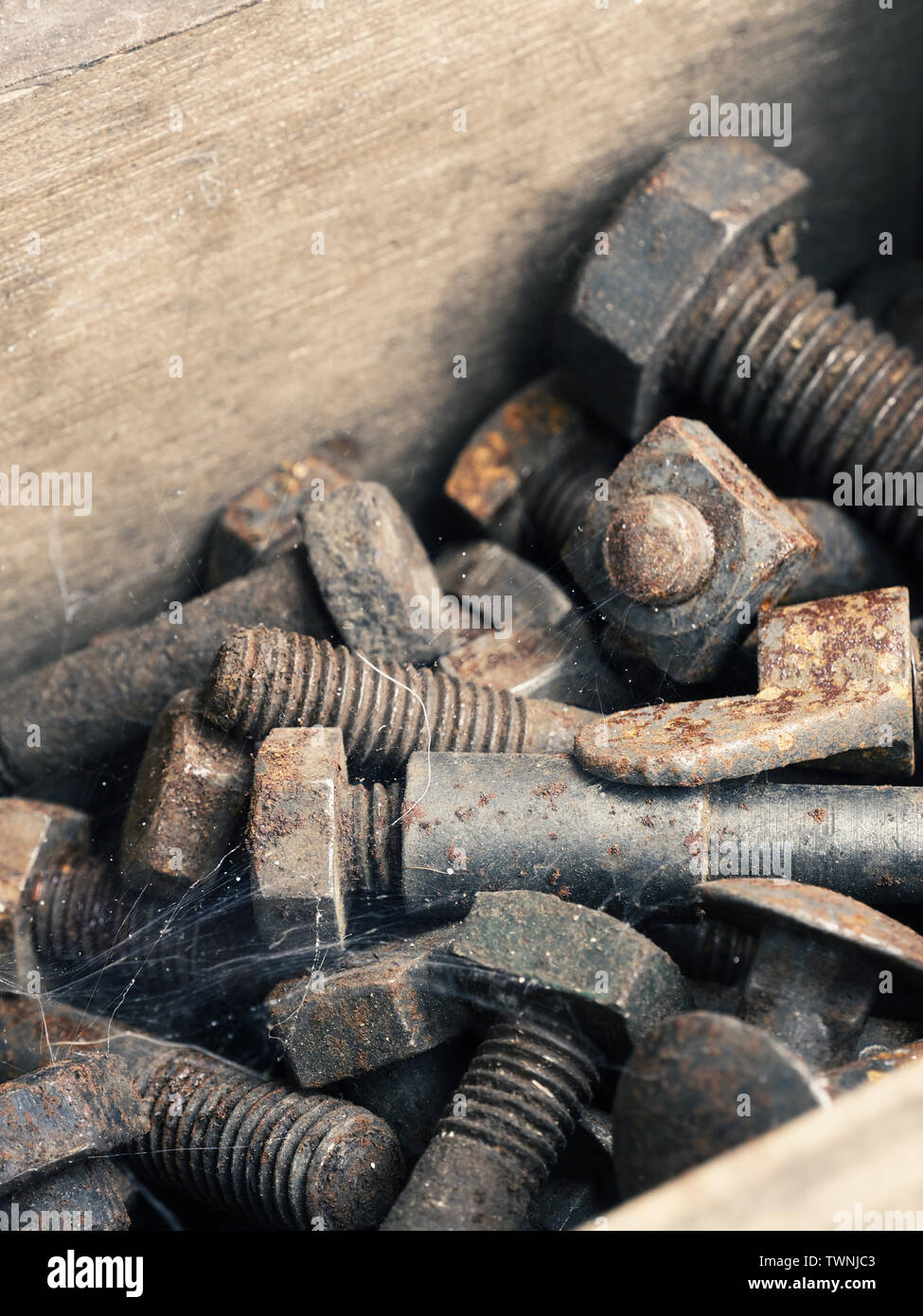 Old rusty bolts and nuts in a wooden box, industrial concept background ...