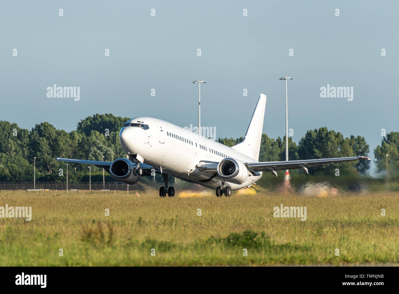 A passenger aircraft taking off from an airport runway Stock Photo - Alamy