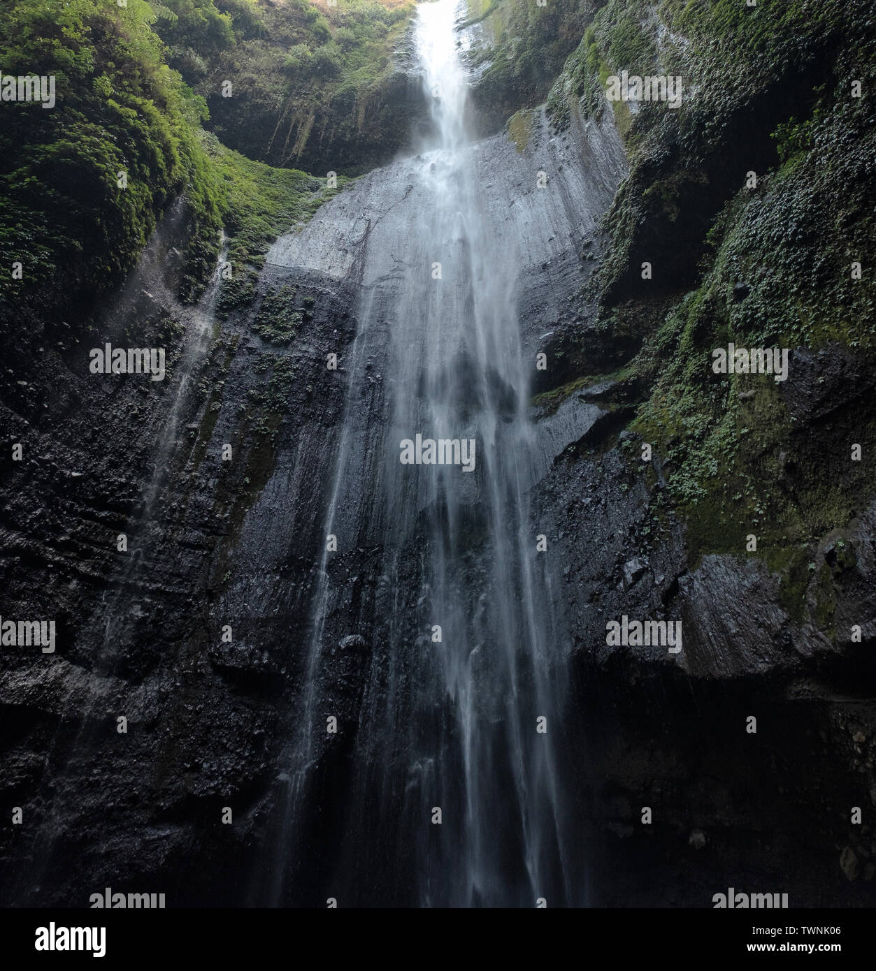 Majestic waterfall flowing on rocky cliff in tropical rainforest ...