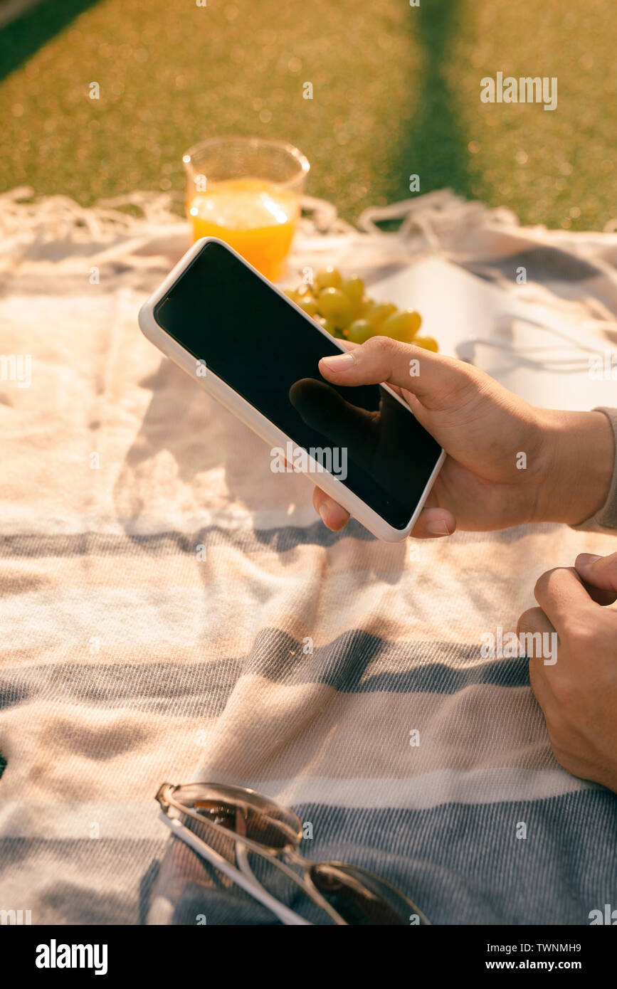 man's hand looking at the media on a smart phone Stock Photo - Alamy