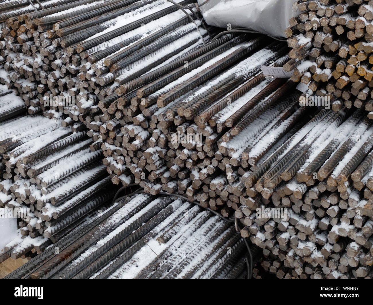 Steel snow covered reinforcement bars at the outdoor warehouse ...