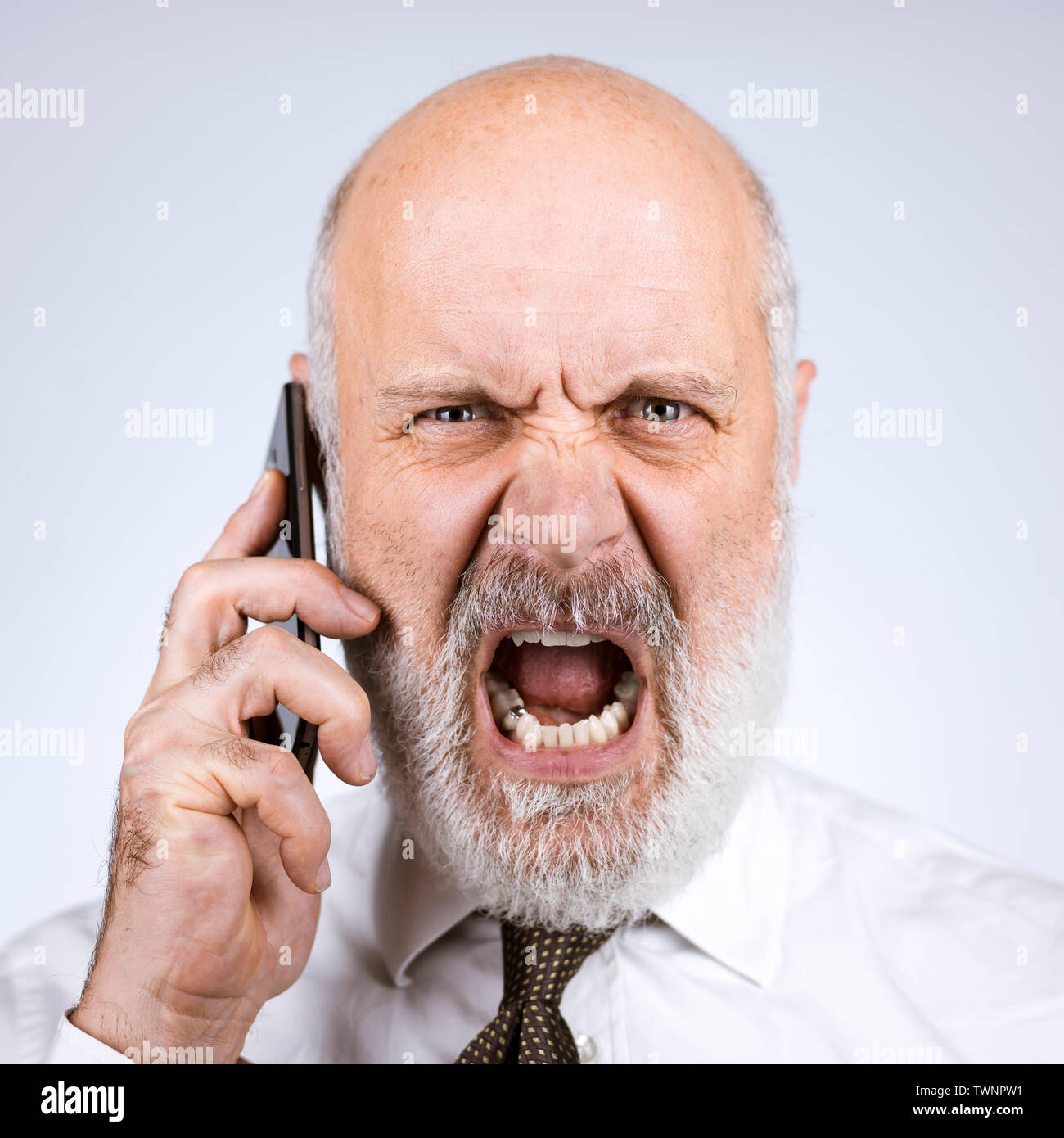 Angry furious mid age businessman having a phone call with his ...