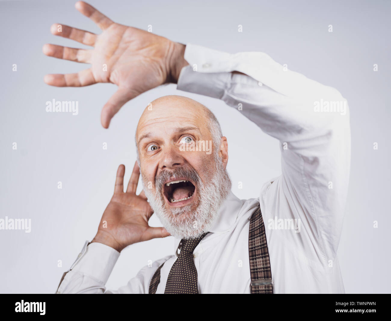Terrified panicked senior man shouting out loud with hands raised Stock ...