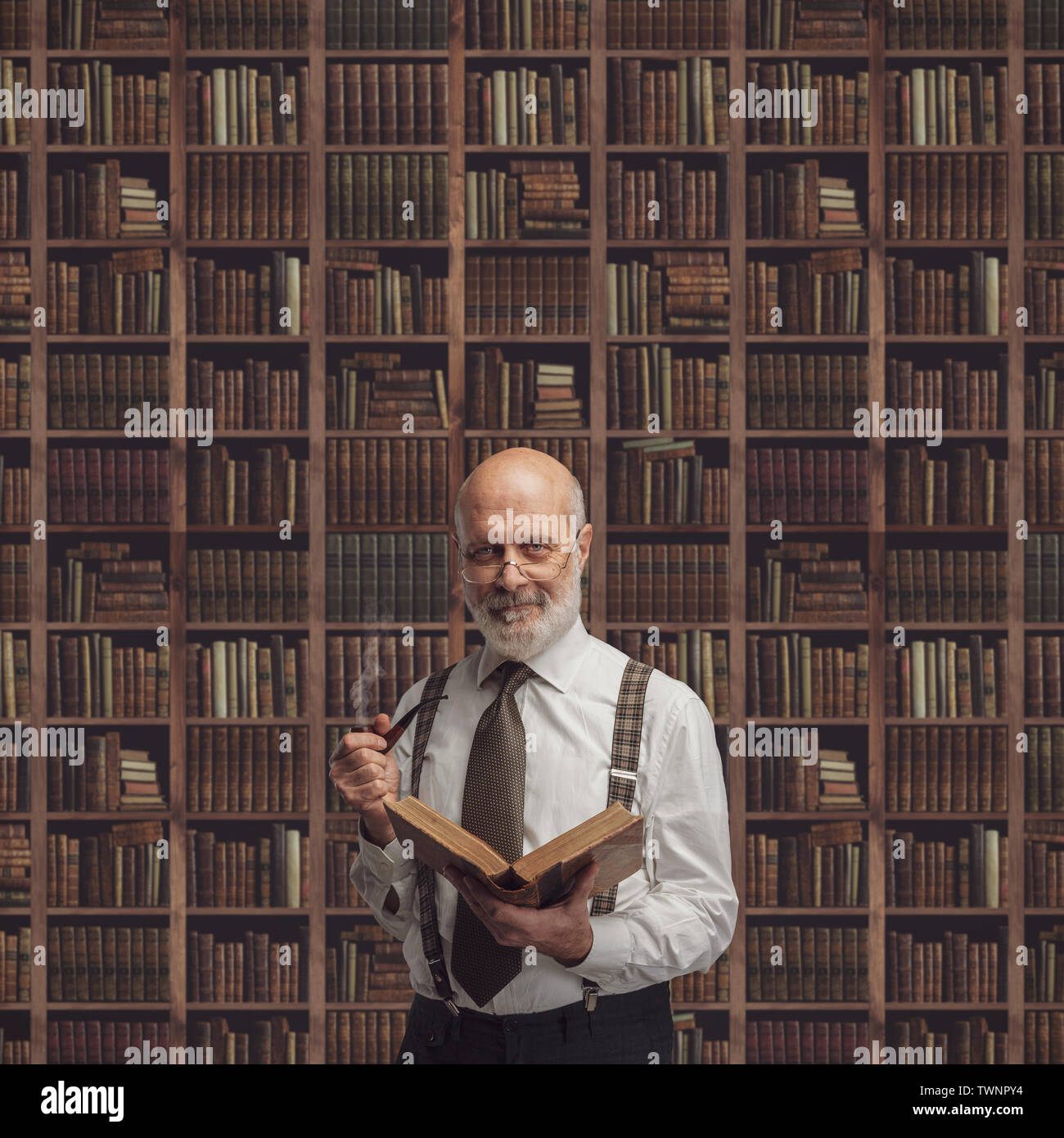 Senior academic professor reading an old book in the library: knowledge ...