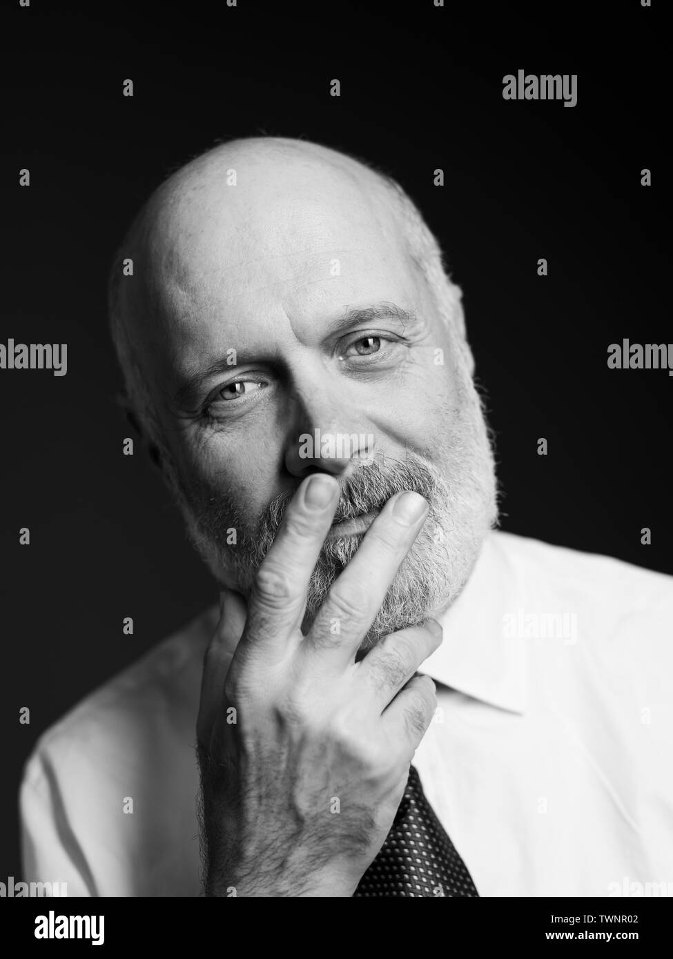 Mature man posing with a hand on his face and looking at camera Stock ...