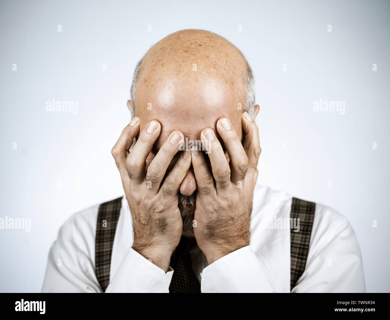 Desperate mature man with head in hands: he is feeling depressed ...