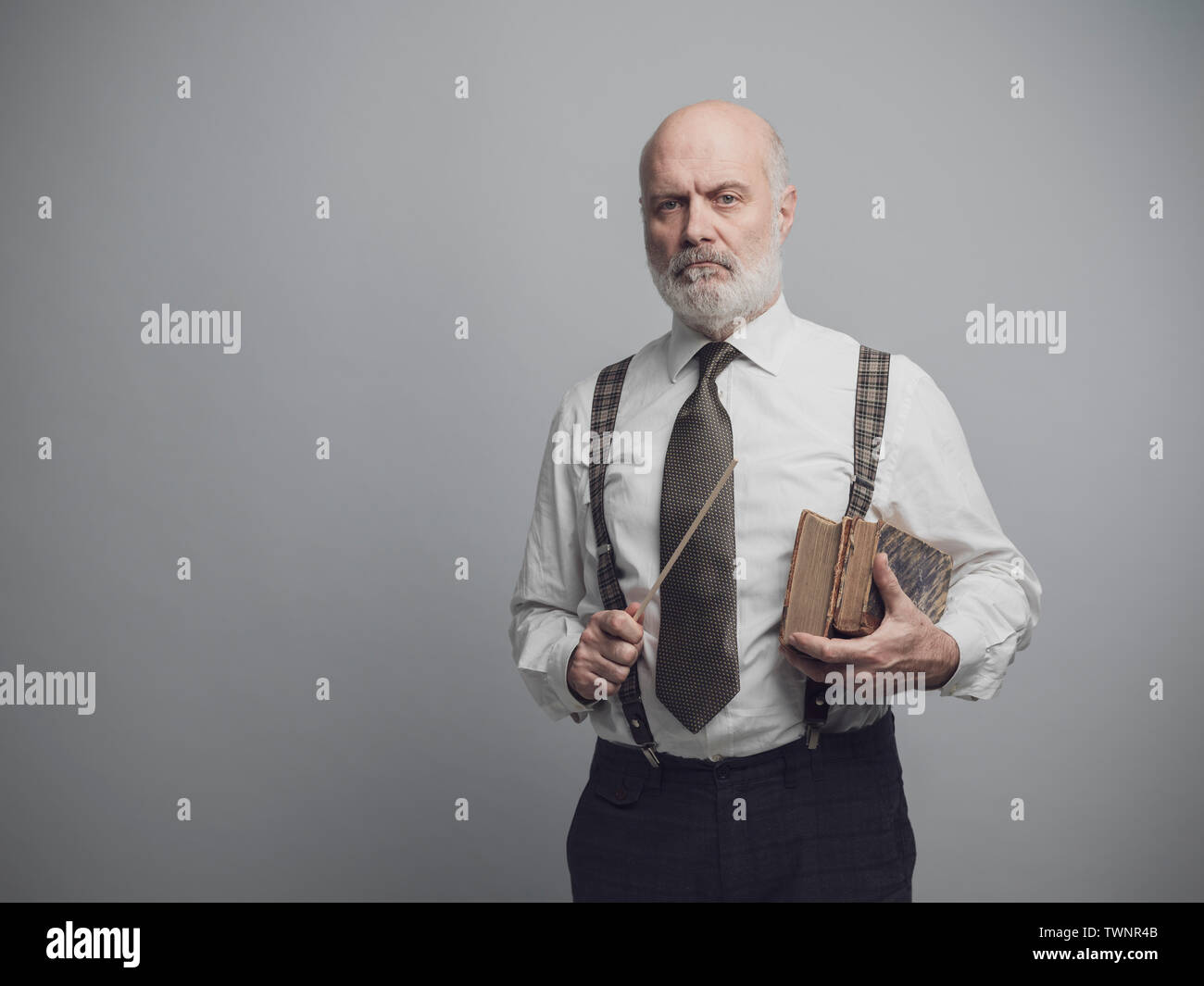 Confident serious academic professor posing with old books: traditional ...