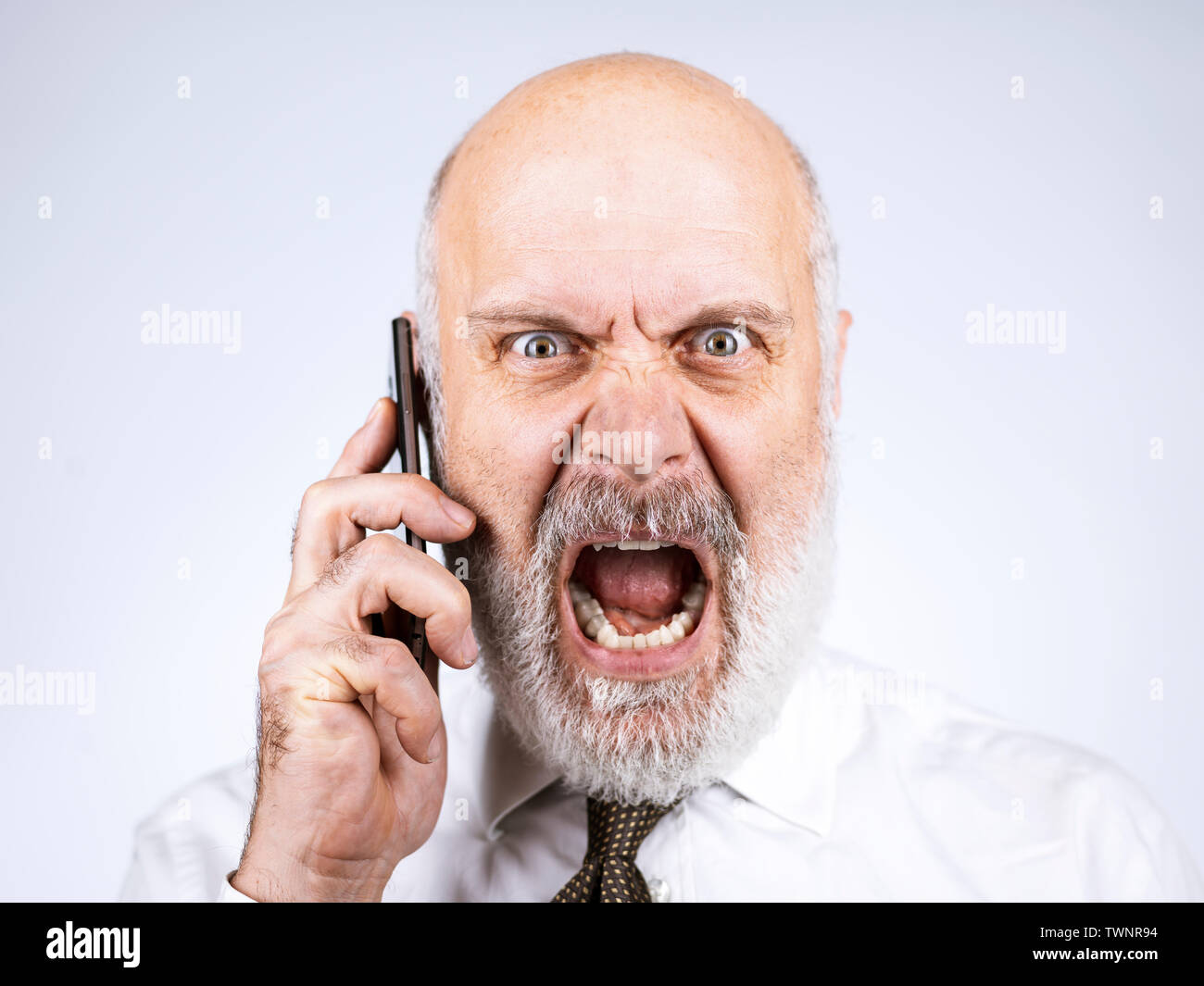 Angry furious mid age businessman having a phone call with his ...