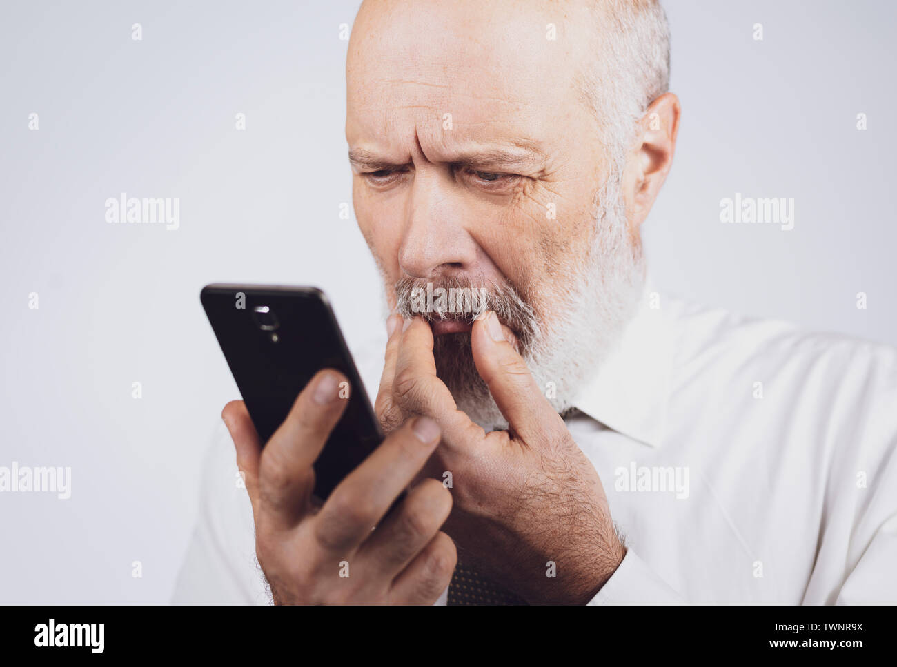Senior man using apps on the smartphone, he is having difficulties and ...