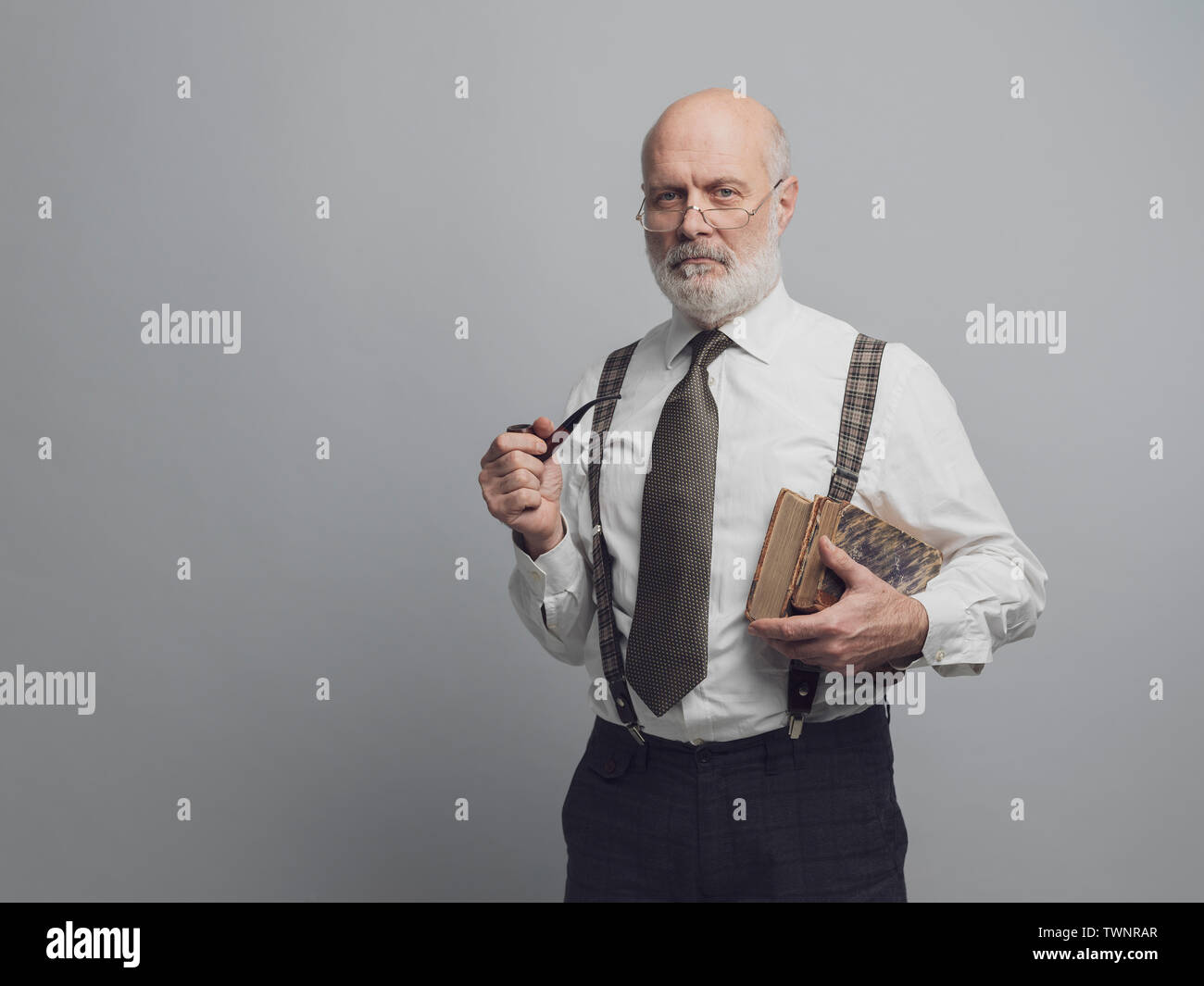 Confident serious academic professor posing with old books: traditional ...