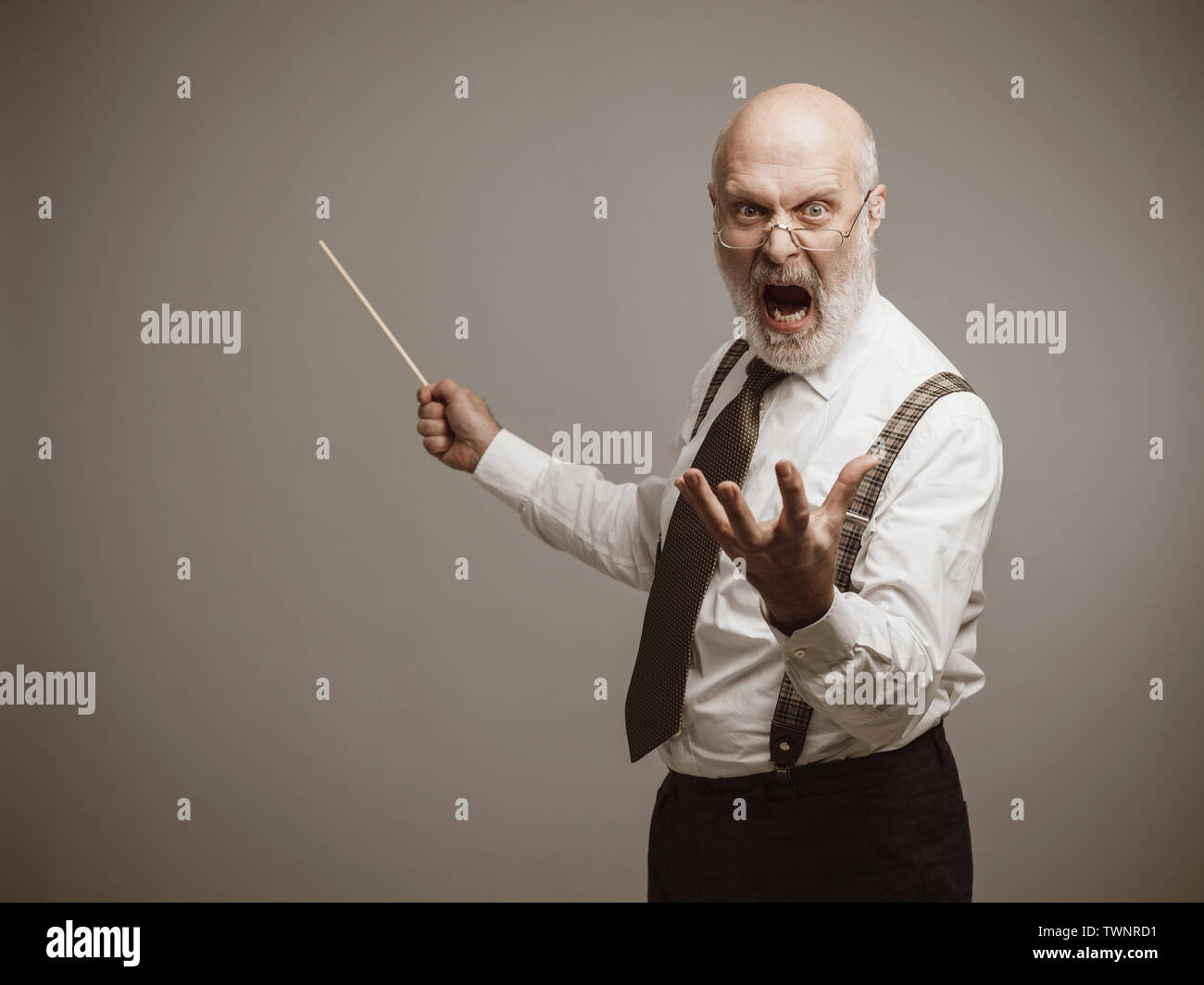 Senior authoritarian professor yelling and pointing at the blackboard ...